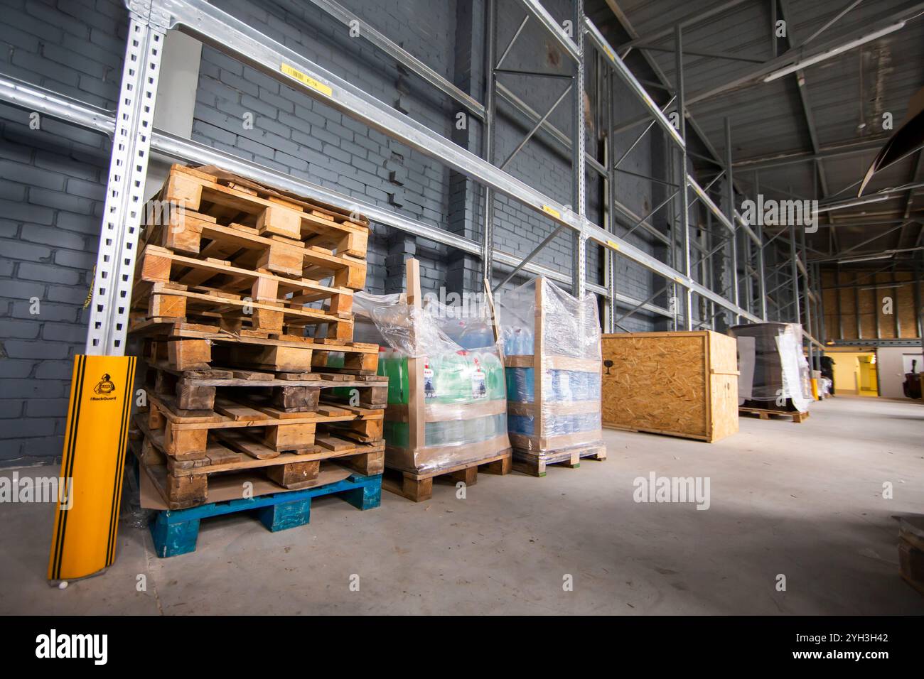 Warehouse interior with stacked wooden pallets, wrapped goods, and ...
