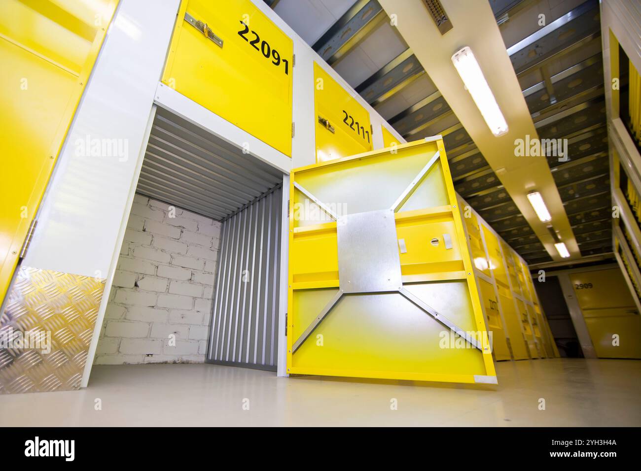Open yellow door revealing an empty metal-walled storage unit in a ...