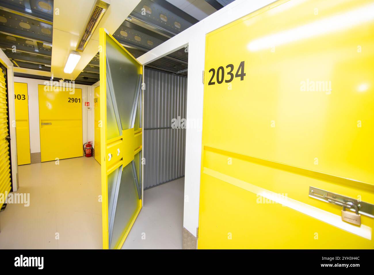 Open yellow door revealing an empty metal-walled storage unit in a ...