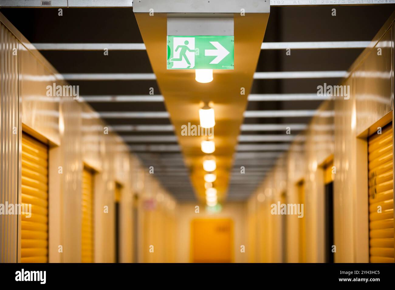 Storage facility hallway with yellow doors, bright lighting, and an ...