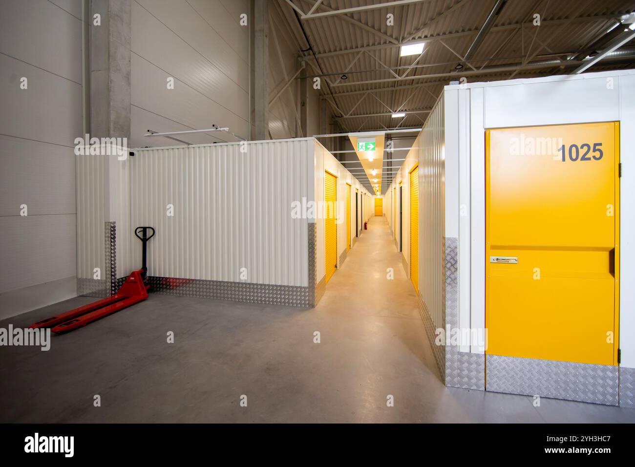 Storage facility with numbered yellow doors, a long corridor, and a red ...