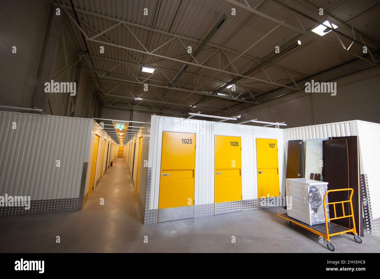 Storage facility with numbered yellow doors, a long hallway, and an ...