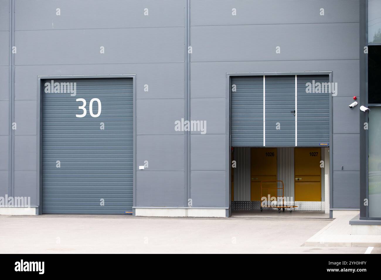 Exterior view of two numbered industrial storage doors on a gray wall ...