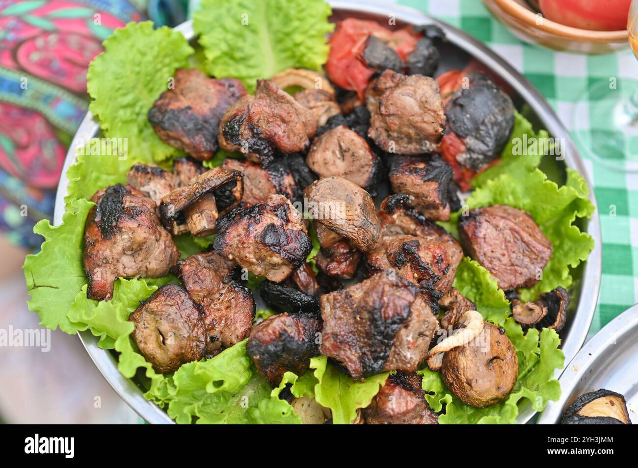 slightly burnt shish kebab meat on a platter with vegetables Stock ...
