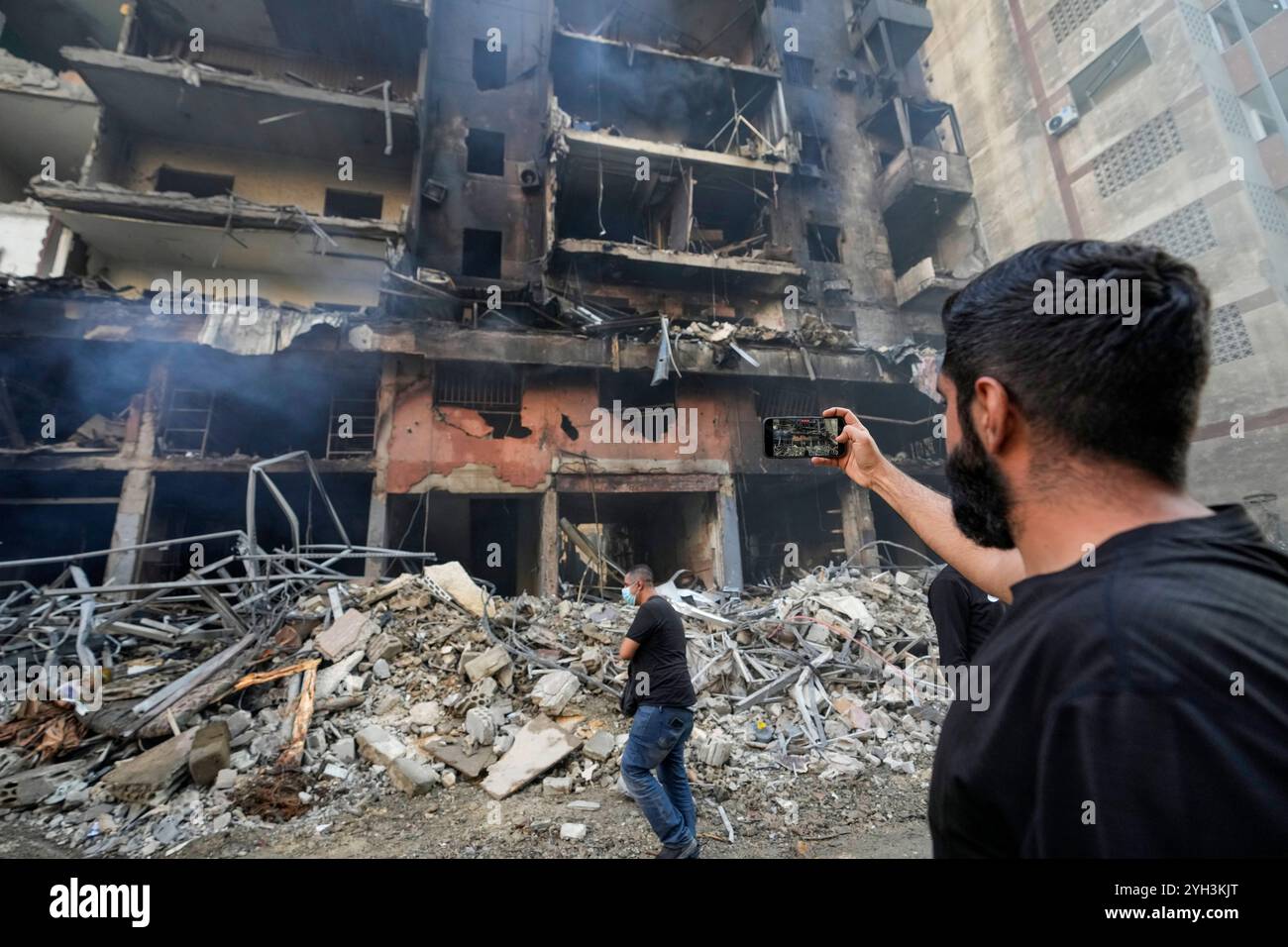Residents check the site of an Israeli airstrike in Dahiyeh, Beirut ...