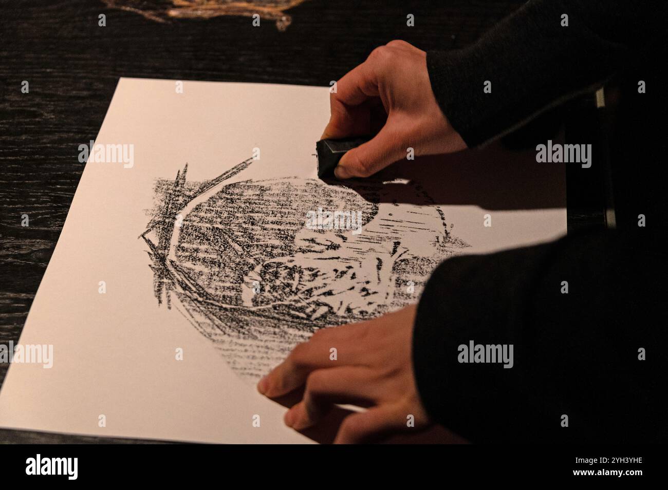 A visitor tries his hand at rubbing an image from a woodcut block ...