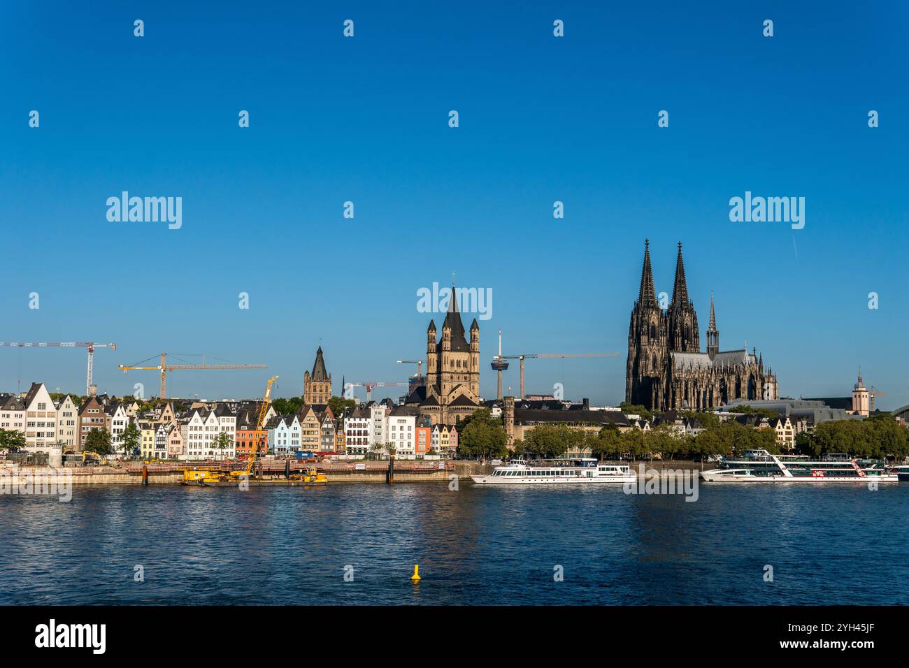 View of Cologne Cathedral with a cargo ship and passenger boat ...