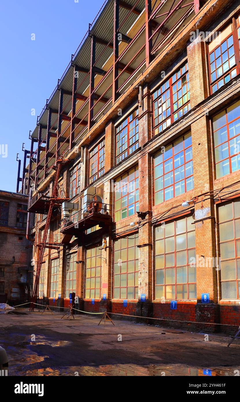 Old industrial courtyard view with red brick facades and tubes of an ...