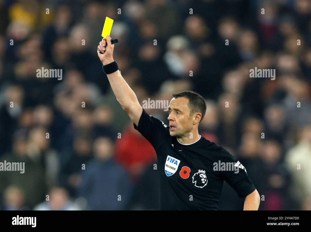 Referee Stuart Attwell shows a yellow card during the Premier League ...