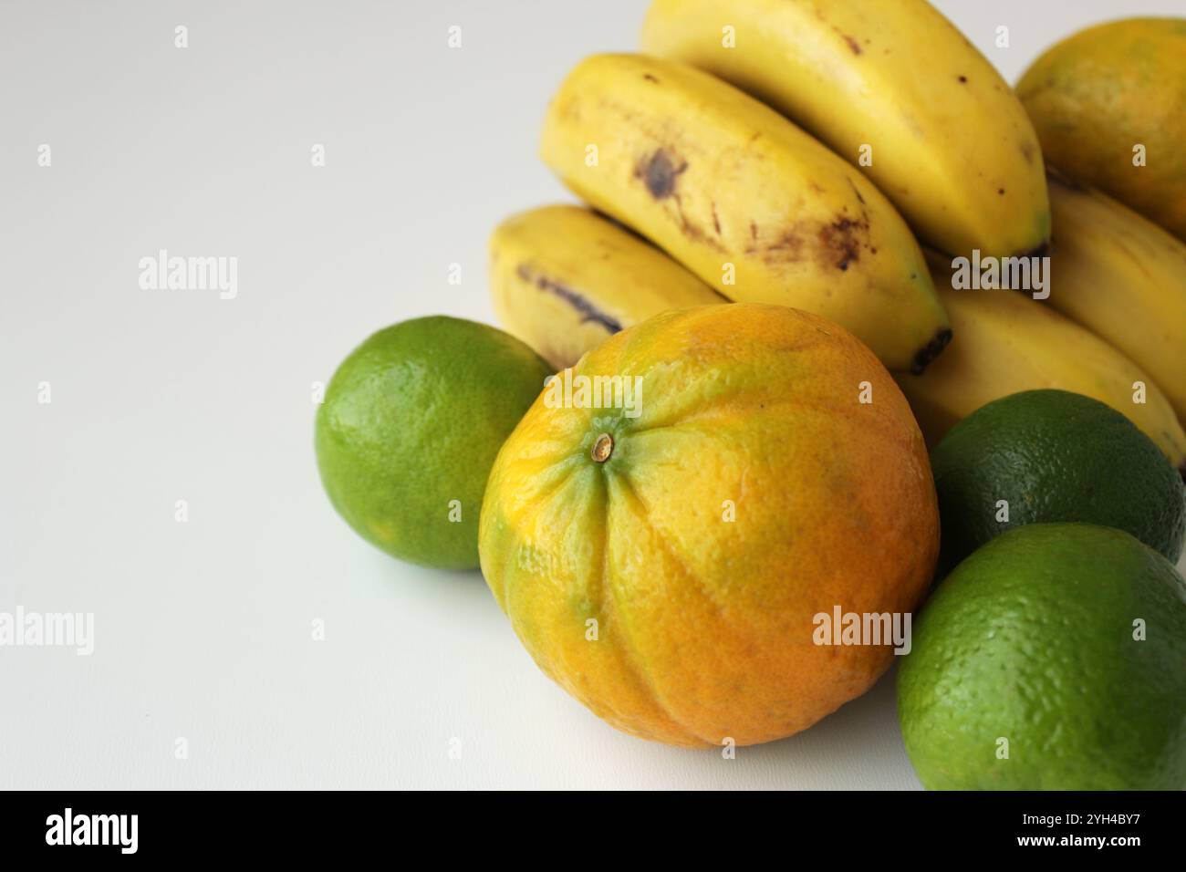 Bananas, limes and oranges on white background. Healthy fresh brazilian ...