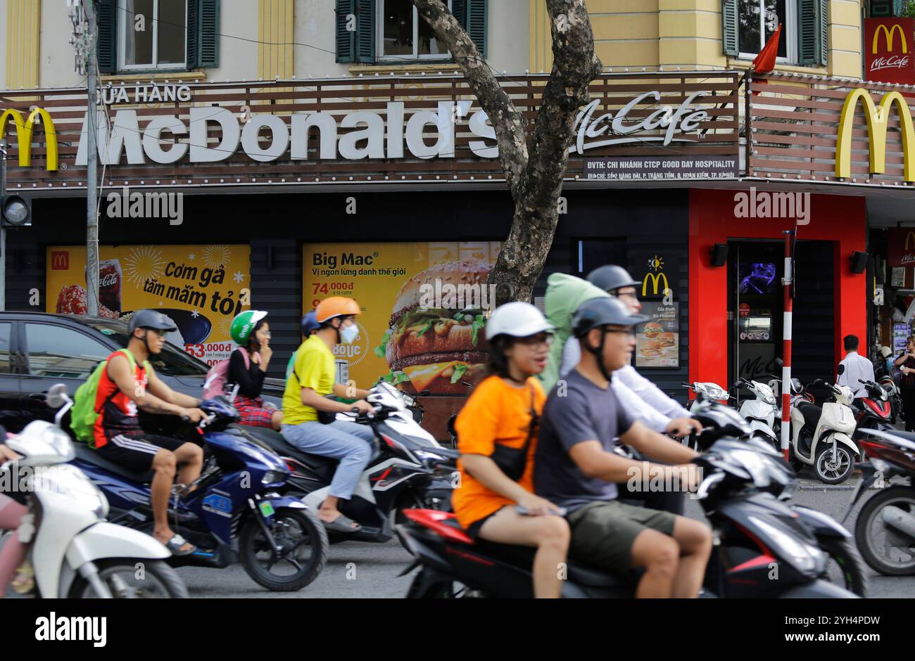 Hanoi, Vietnam - July 5, 2023: People ride their motorbikes past a ...