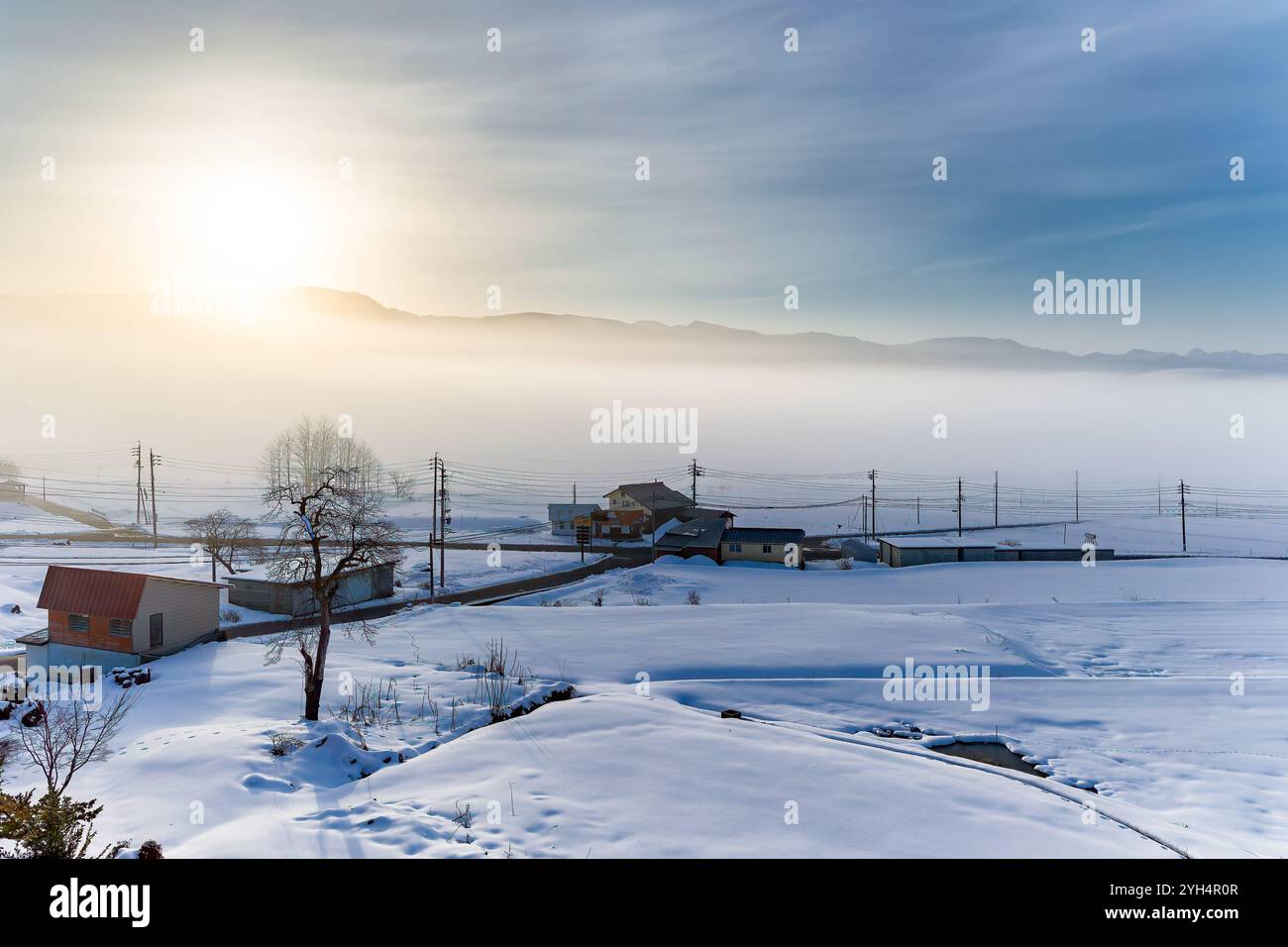 Sunrise through fog over a peaceful, rural snowy landscape (Togari ...
