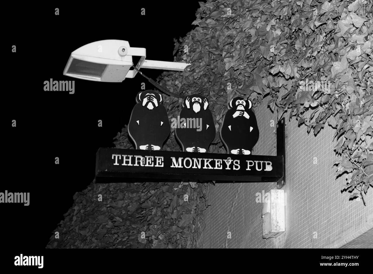 Eilat, Israel- May 10, 2024: Three Monkeys Pub bar street sign in black ...