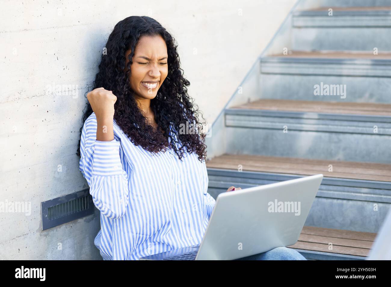 An Excited Young Woman is Joyfully Celebrating Her Success While Using ...