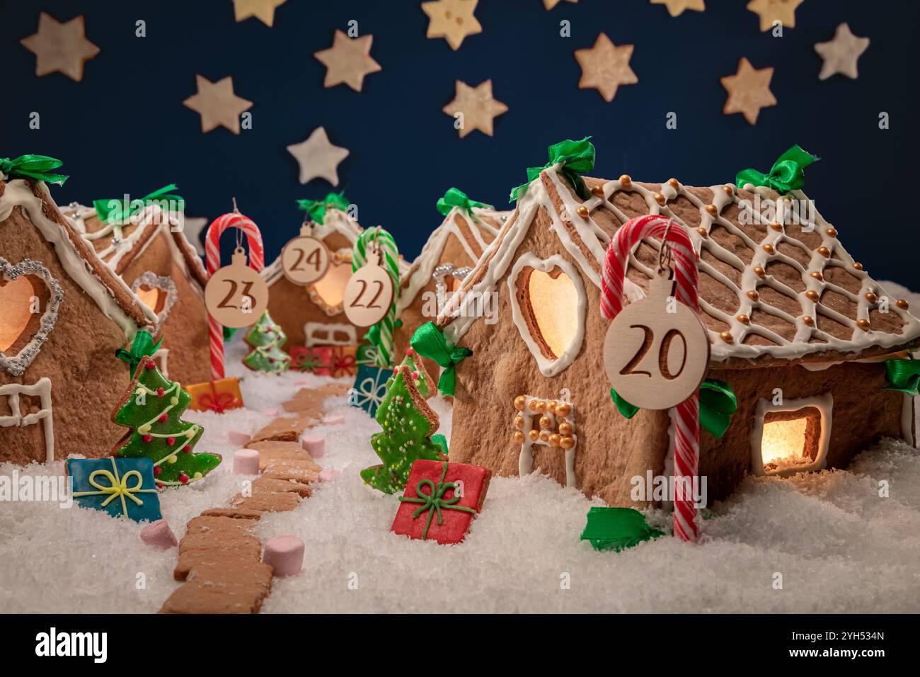 Christmas gingerbread village with stars at night on snowy scene ...