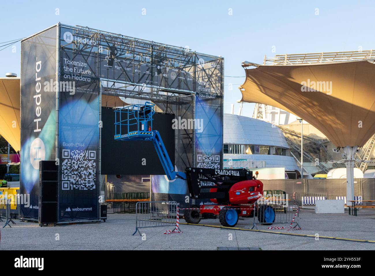 Workers using a telescopic handler are preparing a stage and a giant ...
