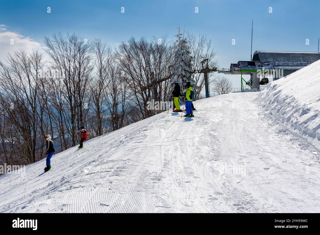 MADARAO, JAPAN - MARCH 14 2024: Skiers waiting at the top of a steep ...