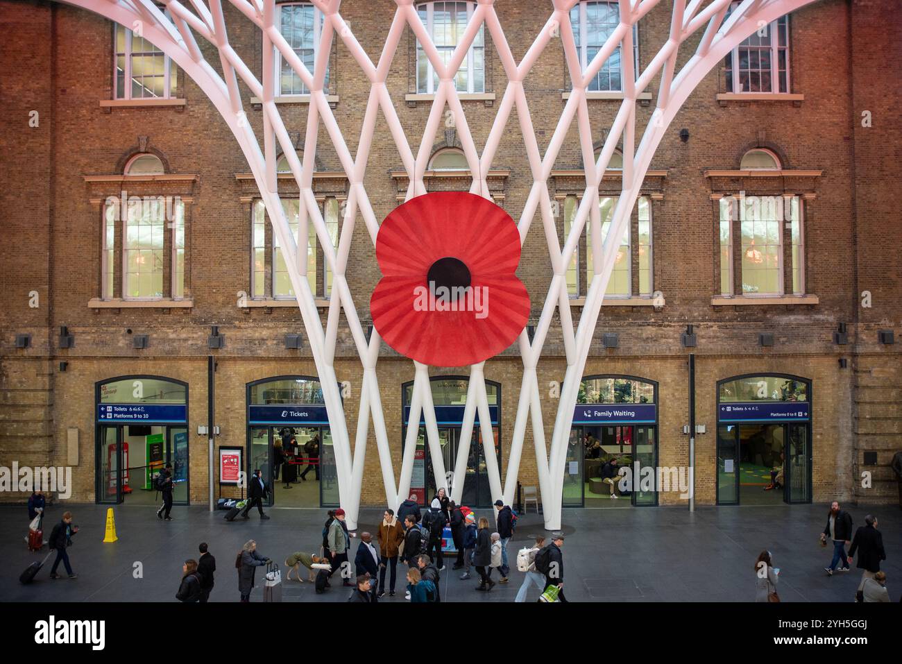 People walk under the large Fiberglass poppy at the King's Cross ...
