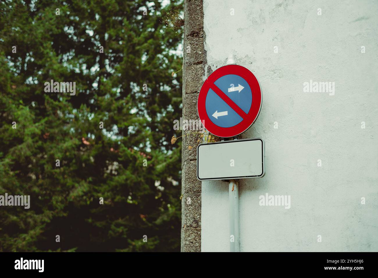 Road traffic sign mounted on a wall with a red circle and blue ...