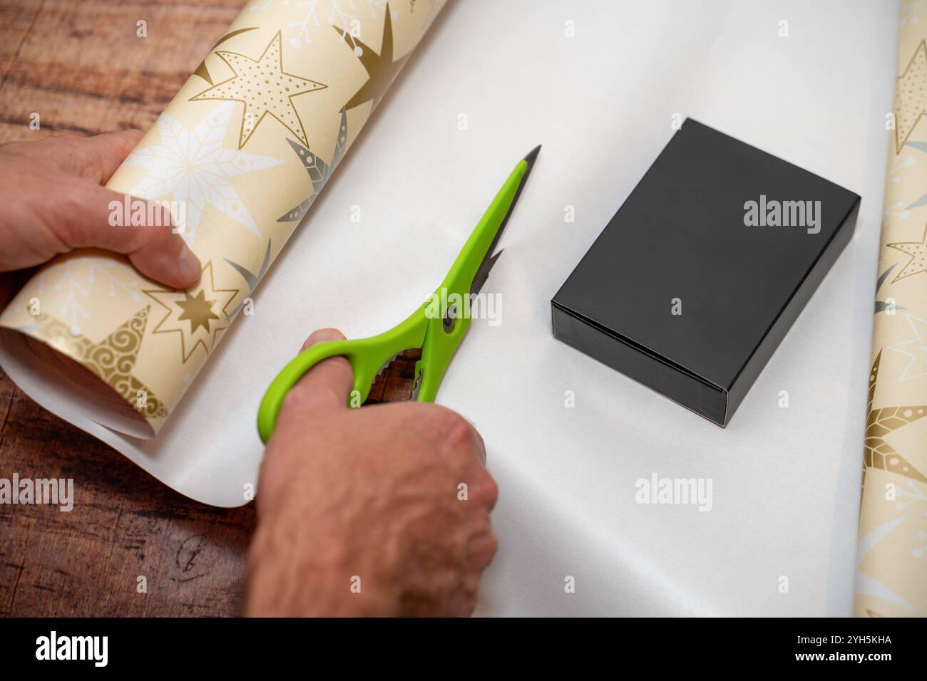 Bavaria, Germany - November 9, 2024: A man cuts wrapping paper with ...