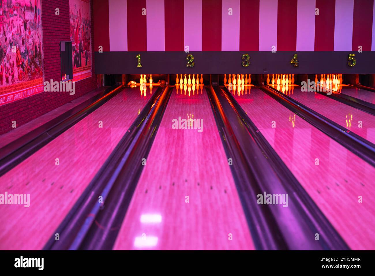 Bowling alley lanes with neon lighting and bowling pins set up ...