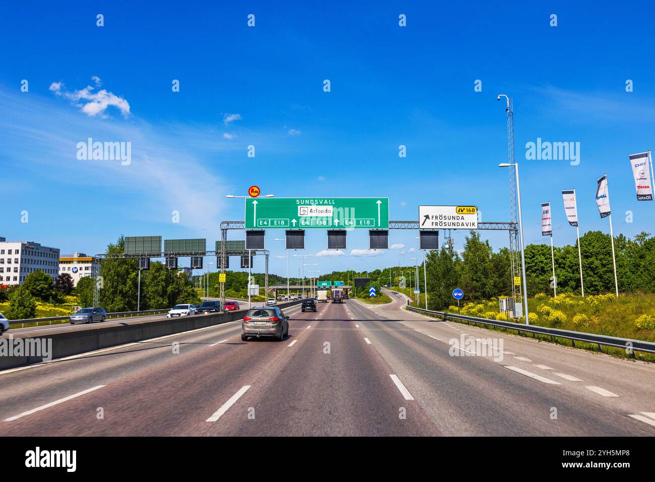 Cars on highway under clear blue sky, with road signs directing towards ...