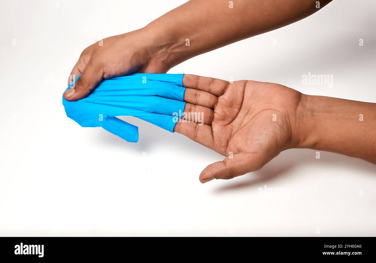 Latin male nurse taking off gloves from his hand. Close-up. Isolated on ...