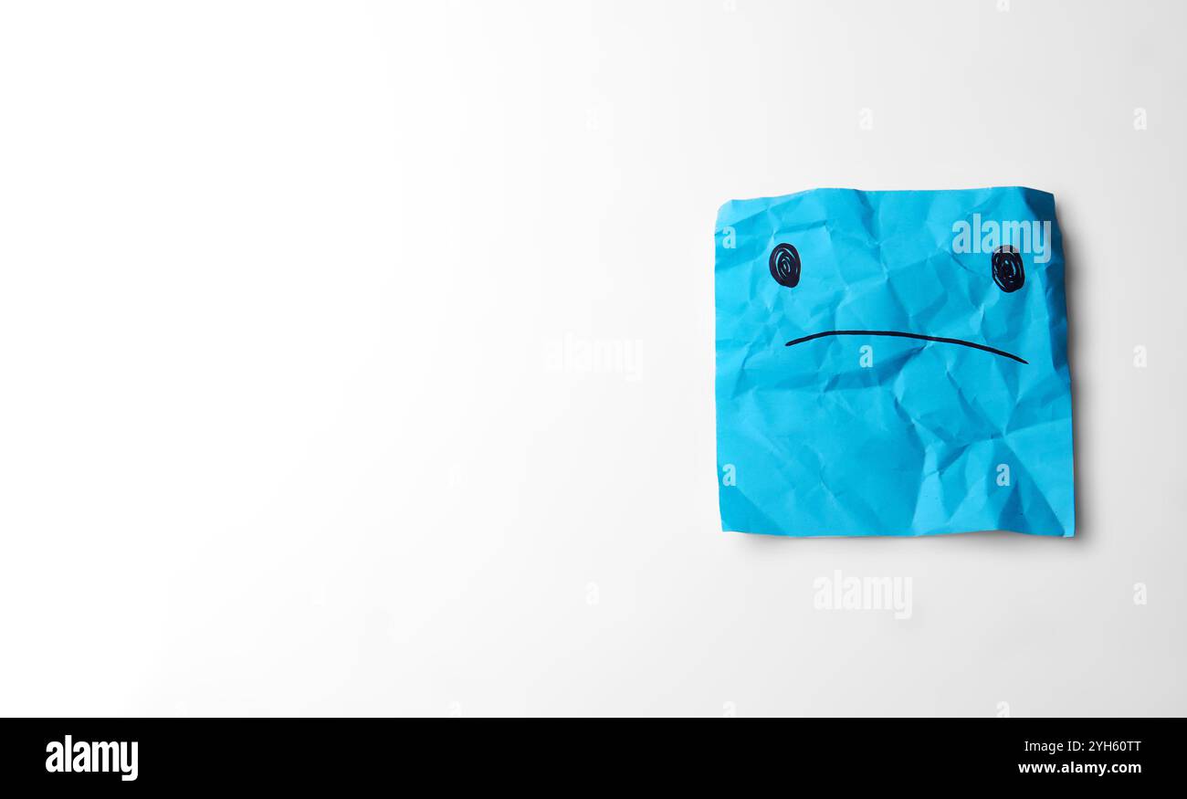 Sad light blue crumpled paper face on a white background. Blue Monday ...