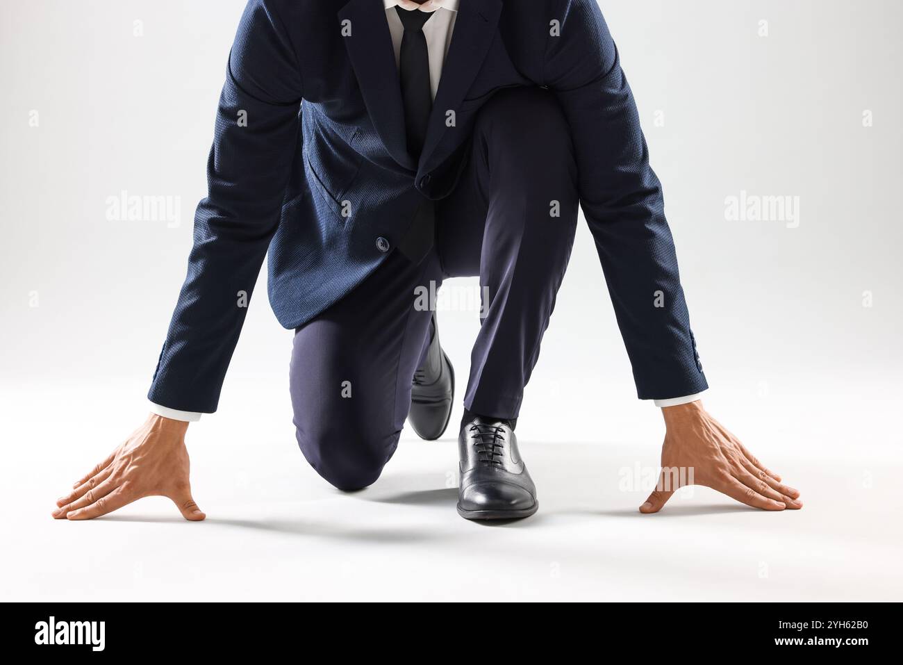 Businessman in starting position for run on white background, closeup ...