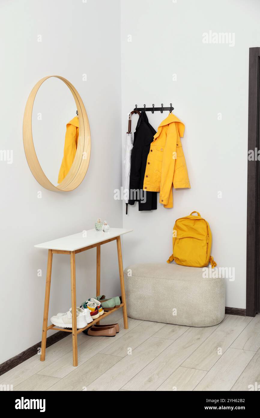 Mirror, rack with clothes and shoe storage bench in hallway. Interior ...