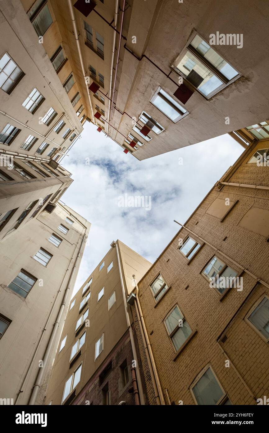 Looking up from an inner courtyard in a building to the sky above, with ...