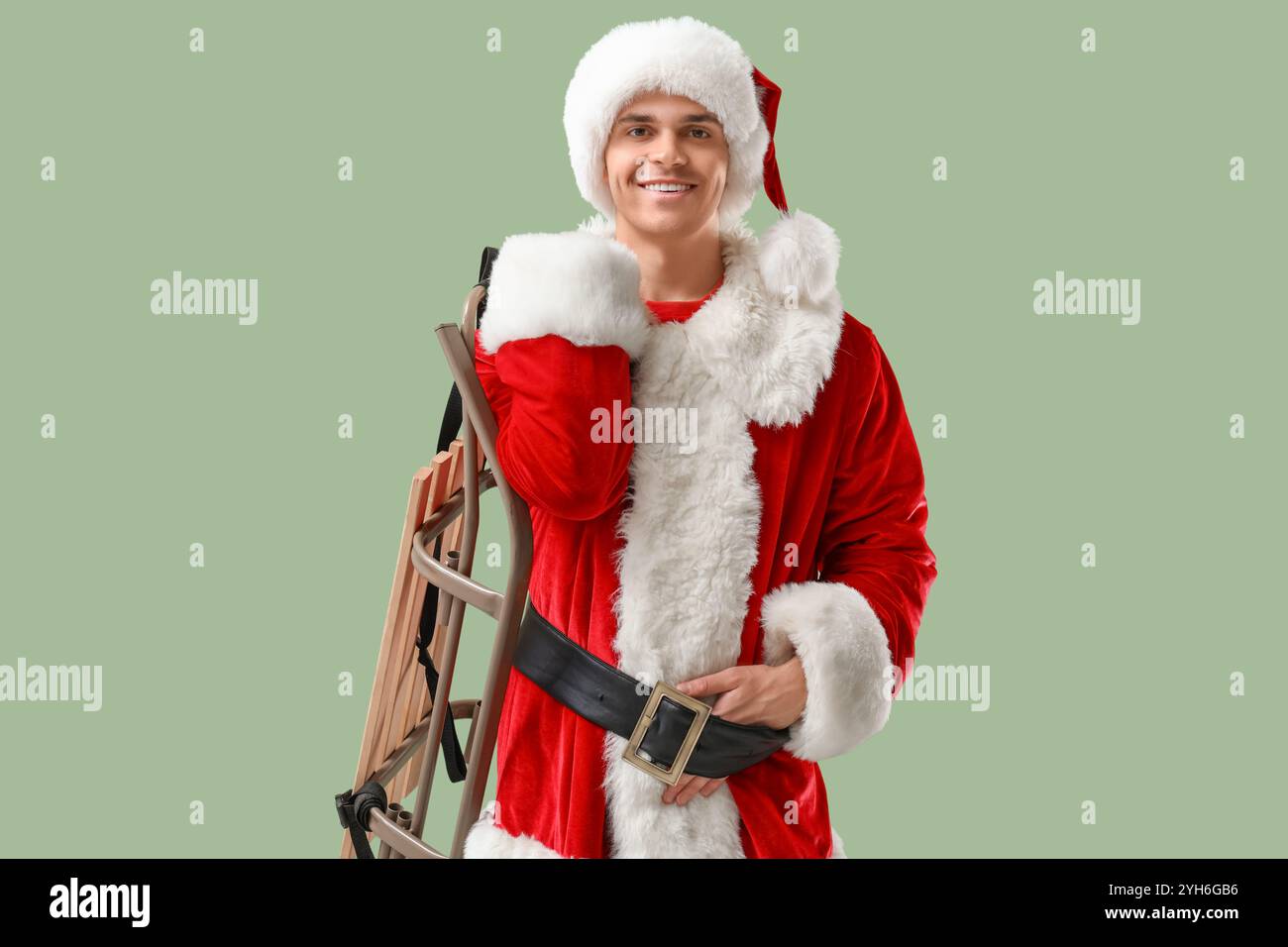 Santa Claus with sledge on green background Stock Photo - Alamy