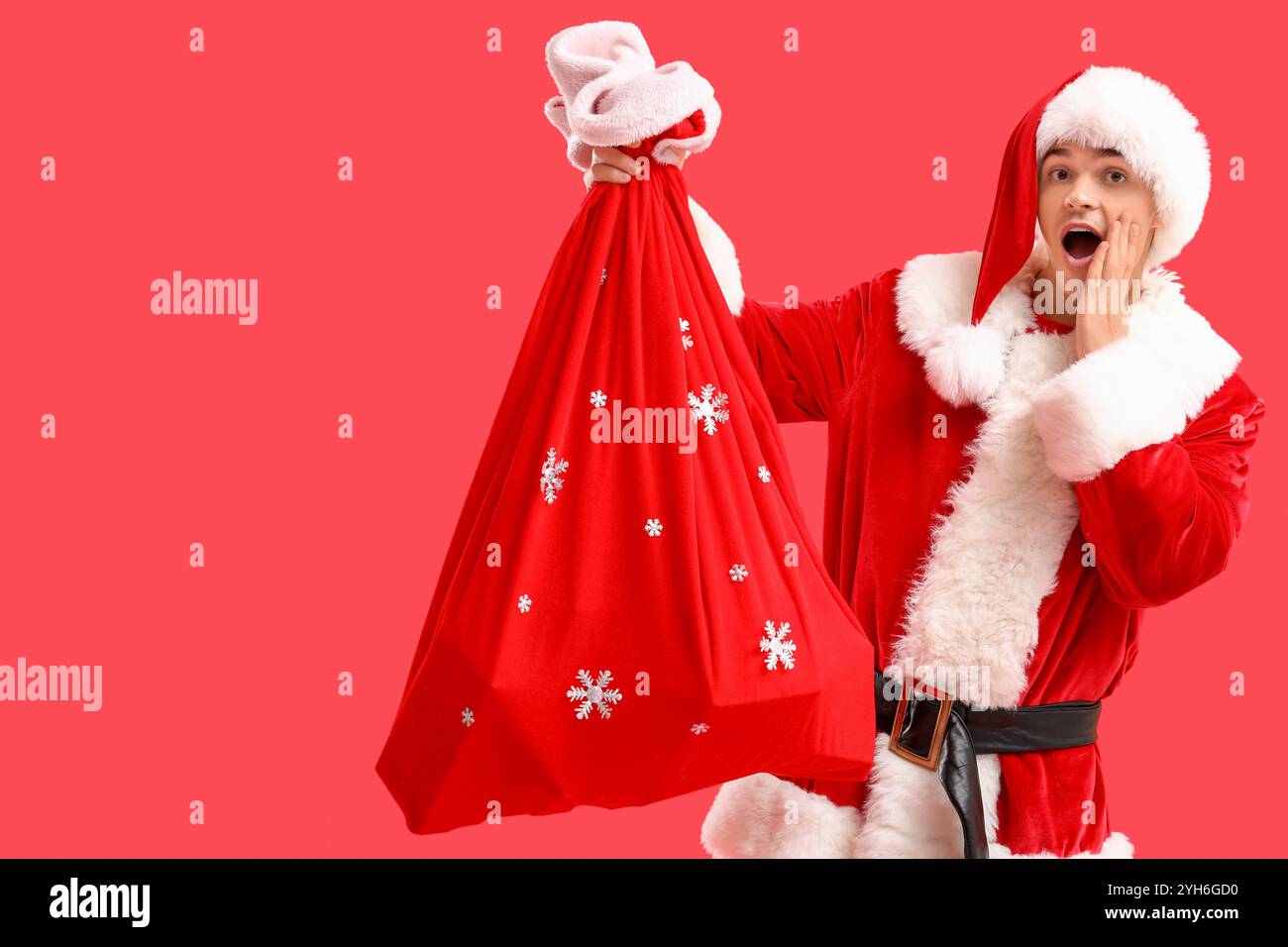 Shocked Santa Claus with bag of gifts on red background Stock Photo - Alamy