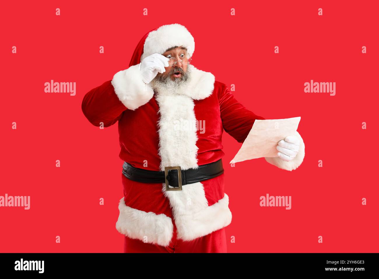 Shocked Santa Claus reading letter on red background Stock Photo - Alamy