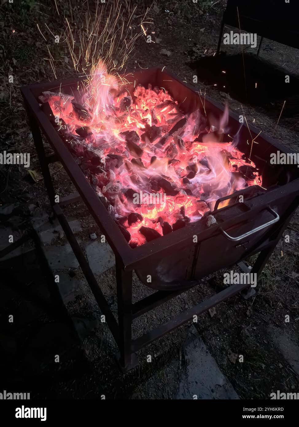 Glowing embers and hot coals prepared for an outdoor barbecue. The ...