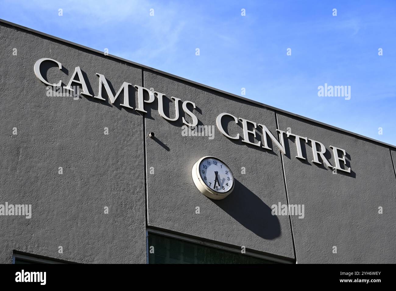 Campus Centre sign on a grey wall, above an analogue clock, at Monash ...