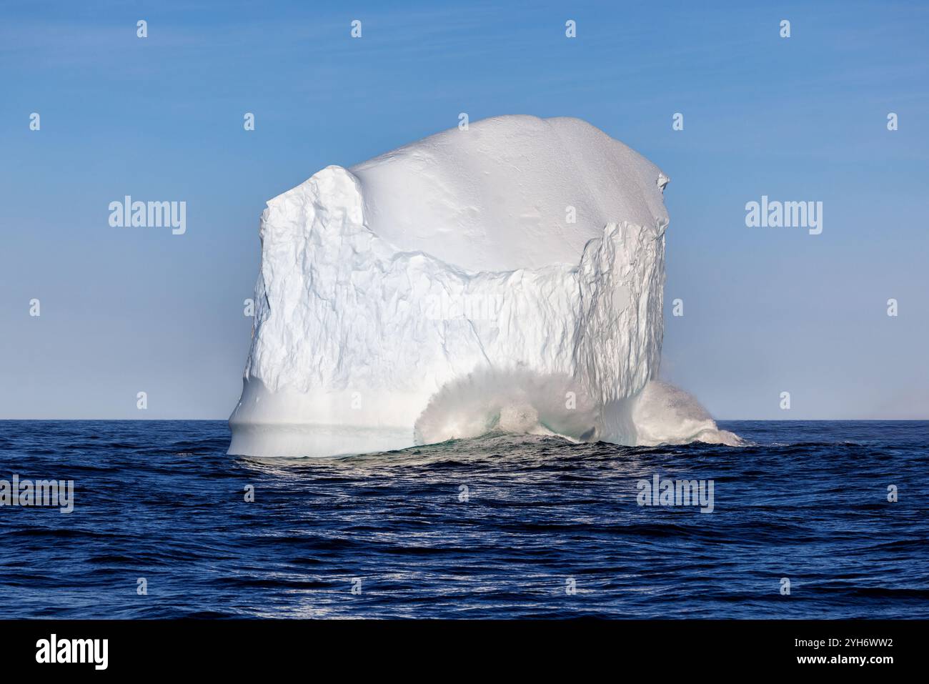 Waves crash into a huge iceberg in Liverpool Land, Greenland. This is a ...