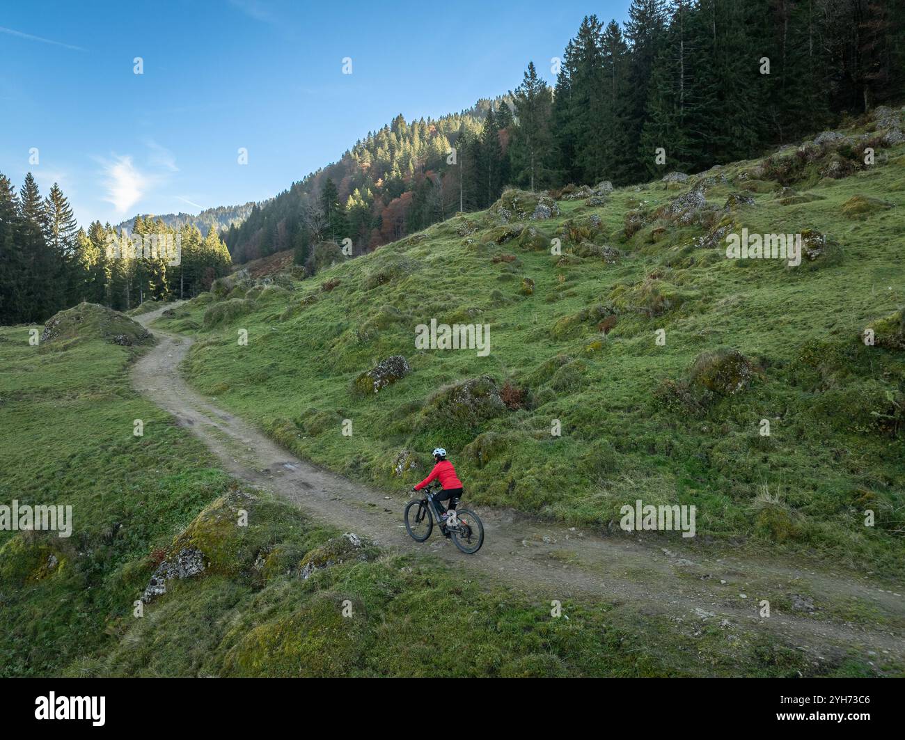 woman riding her electric mountain bike in the Bregenz Forest mountains ...