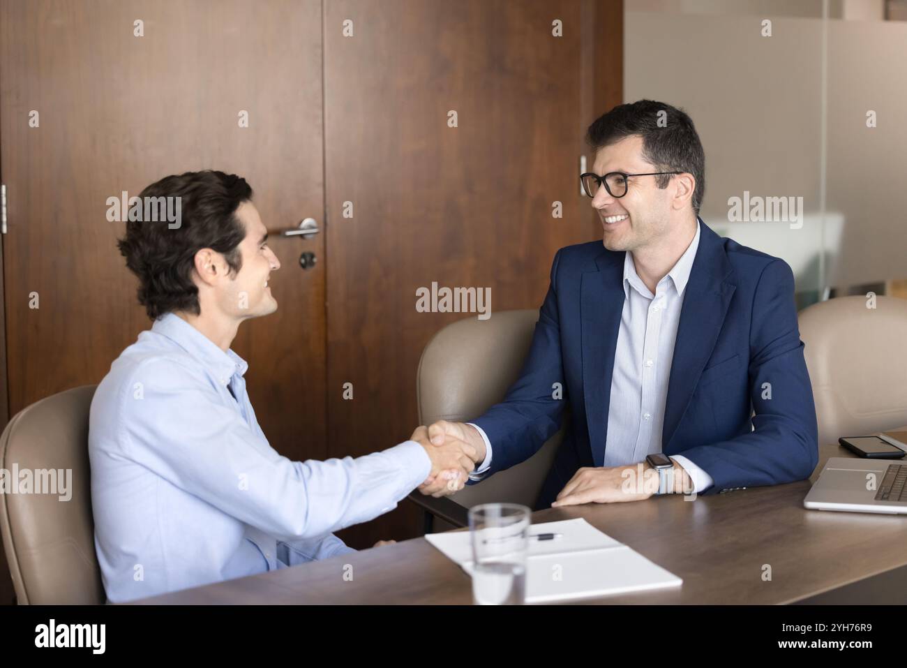 Happy successful male business partners shaking hands after negotiation ...
