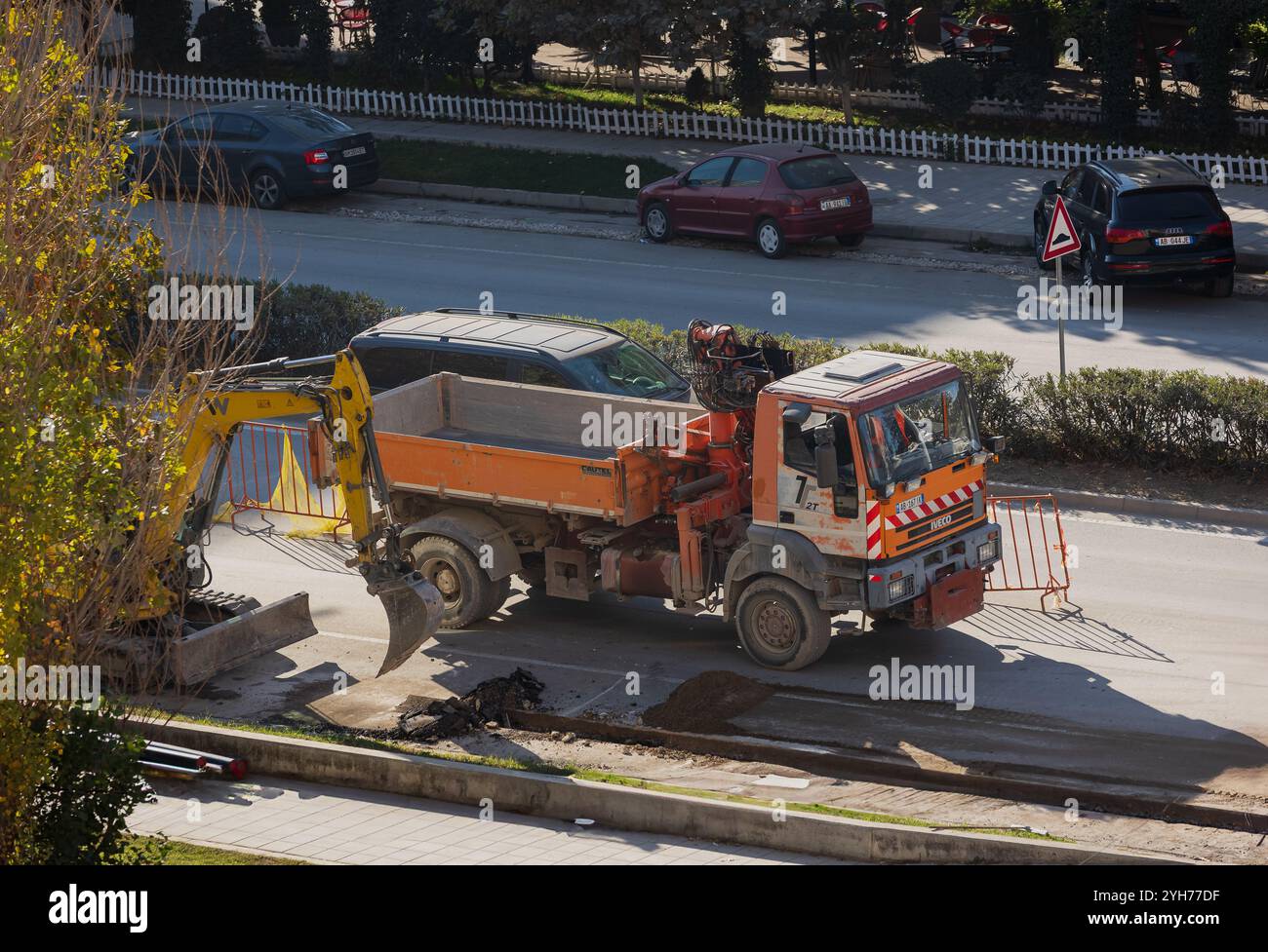 Concrete leveling for road construction site with truck with dirt and a ...
