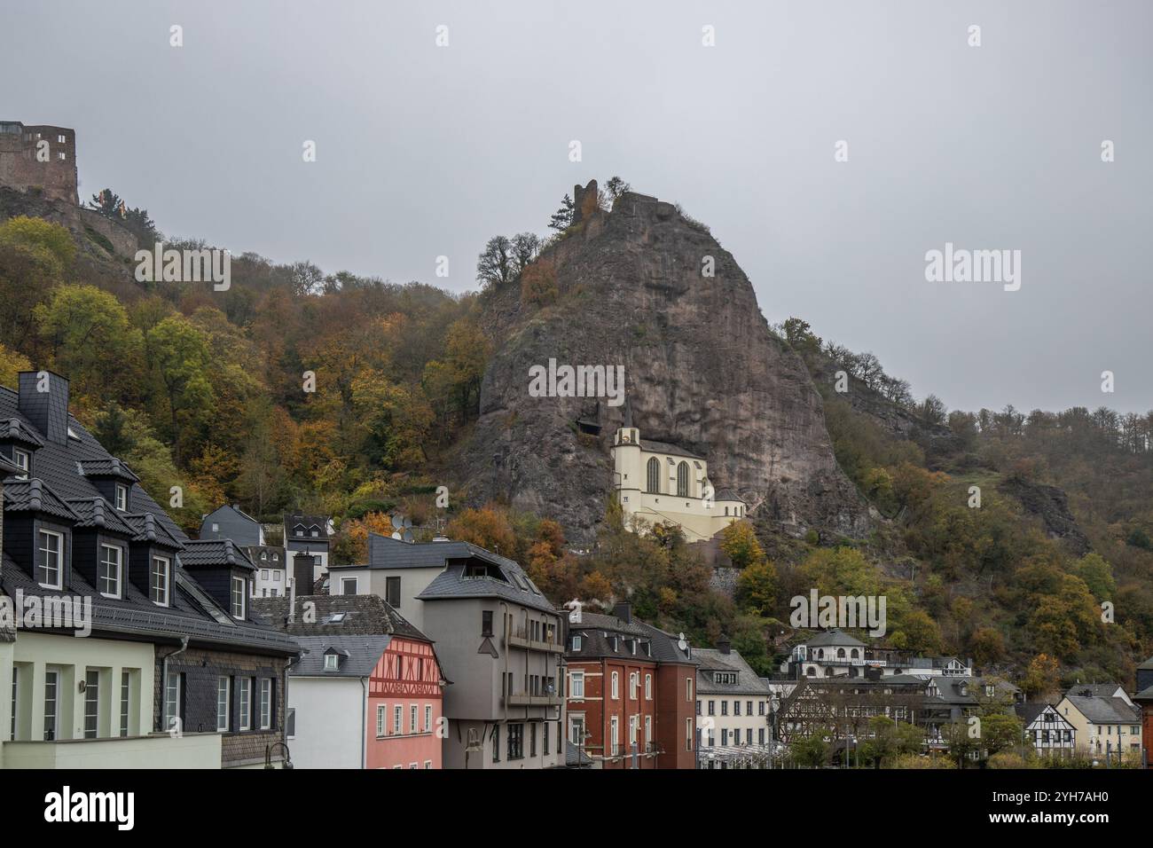 An old half-timbered town in autumn. Church built into a rock ...
