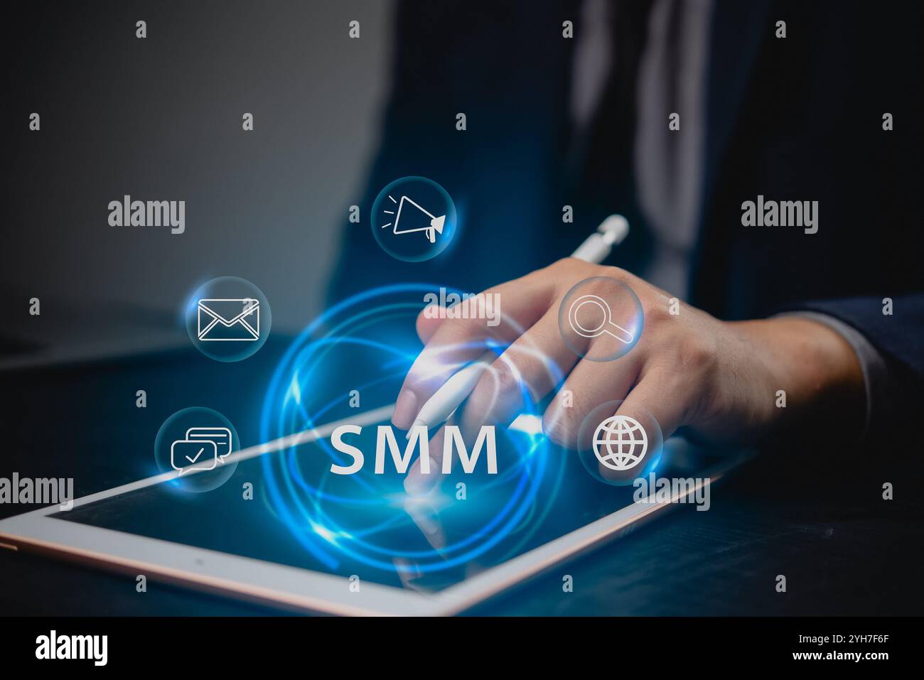 A close-up of a hand using a tablet with digital icons for social media ...