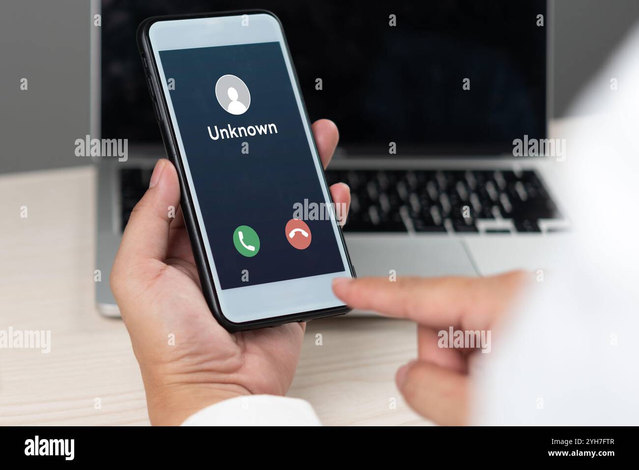 hand holding a smartphone displaying an incoming call from an unknown ...