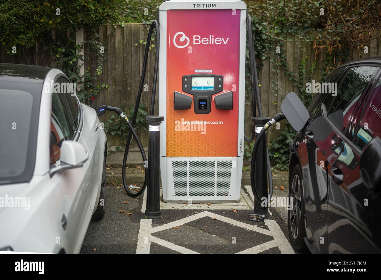 Electric vehicles charging at a public charging point in a council car ...