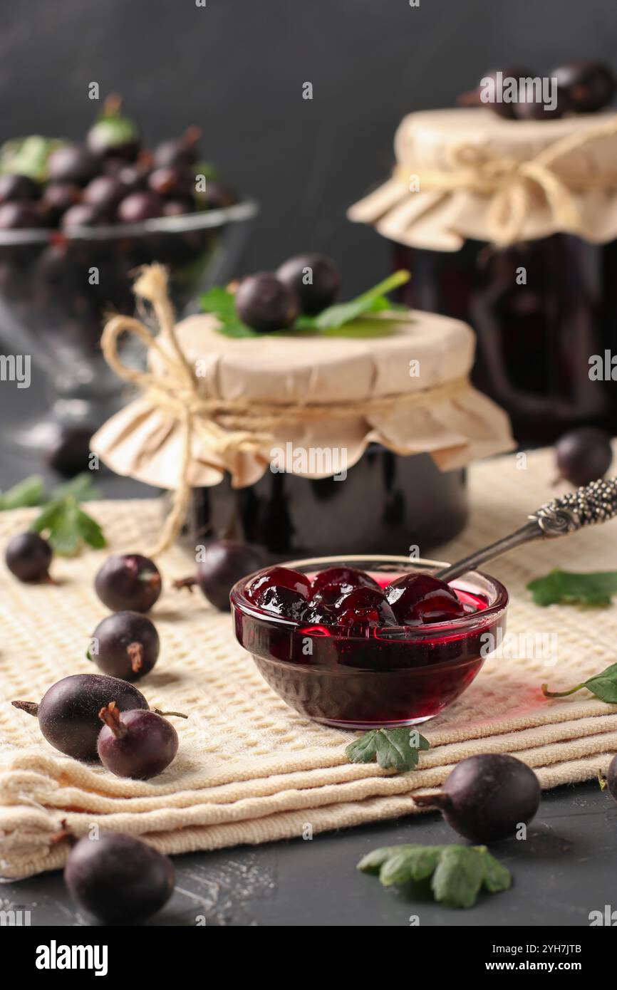 Homemade gooseberry jam in transparent bowl and in jars on gray ...