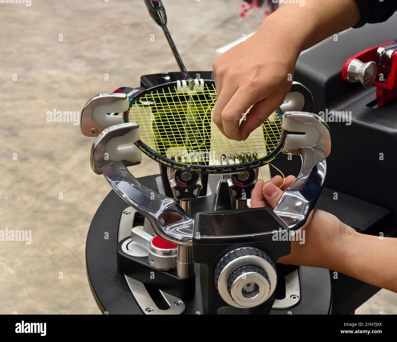 Strings a badminton racket on a racket stringing machine Stock Photo - Alamy