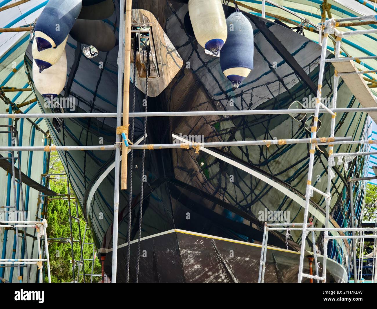 A boat is carefully lifted under a covered structure Stock Photo - Alamy