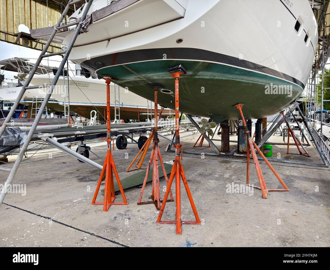 A boat is carefully lifted under a covered structure Stock Photo - Alamy