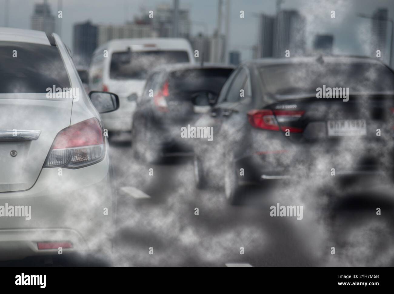 Cars stuck in heavy traffic on a city highway, with visible smog and ...
