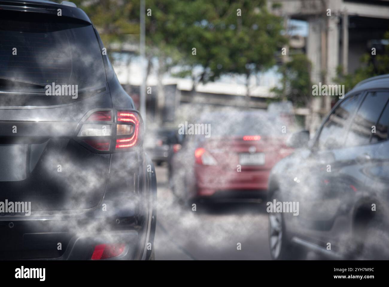 City traffic with visible car exhaust fumes, emphasizing urban air ...